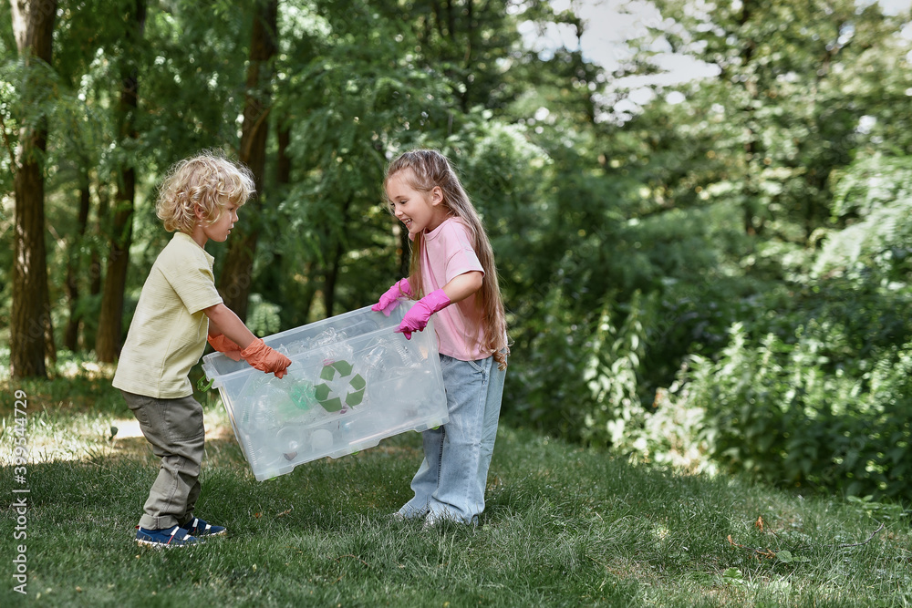 Collecting garbage. Two cute little boy and girl holding recycle bin ...