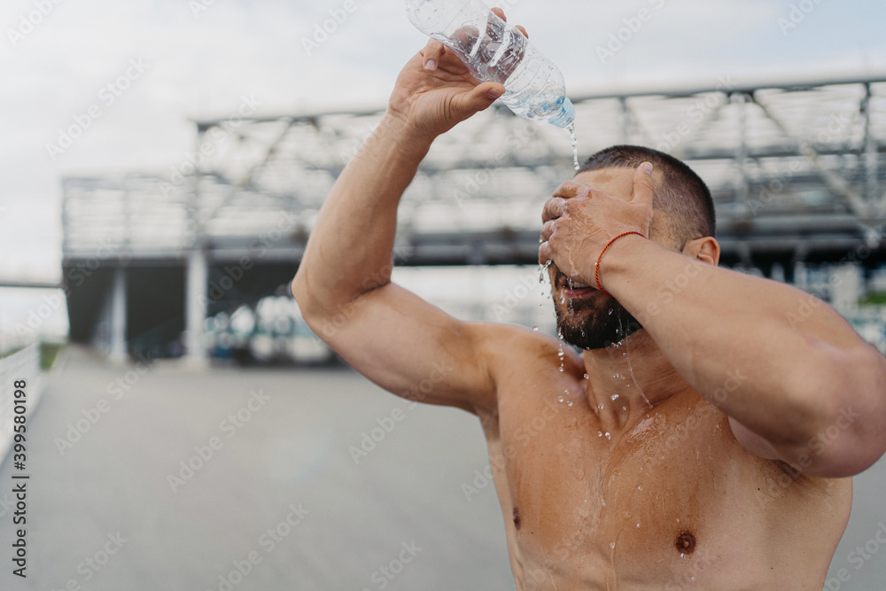 Exhausted sportsman splashes fresh cold water over head, tries to ...