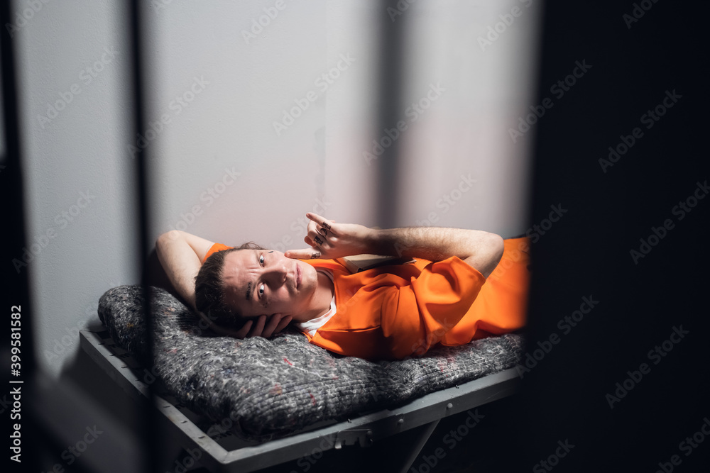 A dangerous serial killer with tattoos on his face in a cell reads the ...
