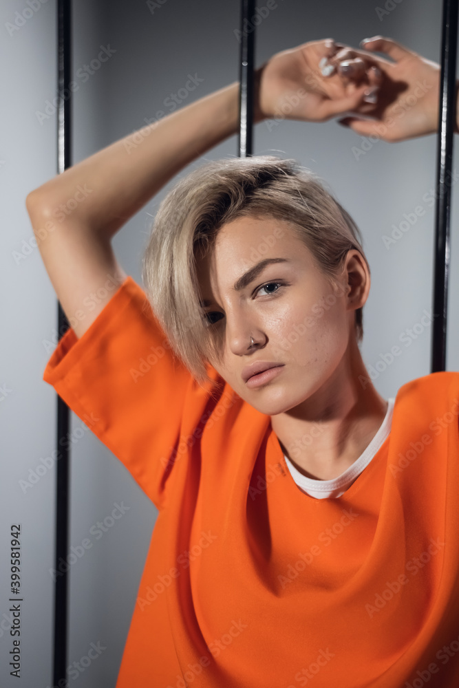 Cute blonde on a photo shoot in the prison, stays behind bars. Stock ...