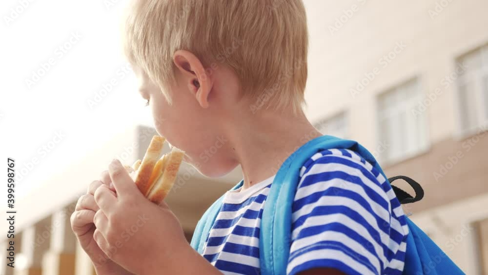 schoolboy eating a sandwich during recess in school. kids lifestyle ...