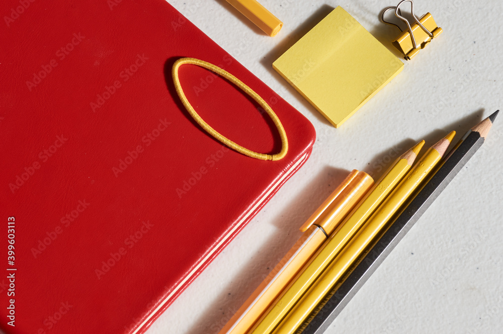 Libreta roja brillante tres lapiceros y marcadores a un lado en ...