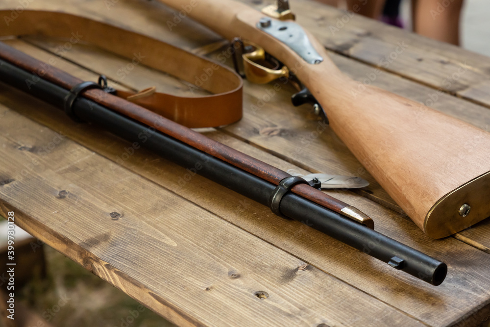 vintage weapon iron muzzle against the background of a wooden butt ...