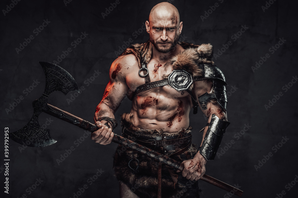 Barbaric bald and handsome viking warrior with muscular build and grimy ...