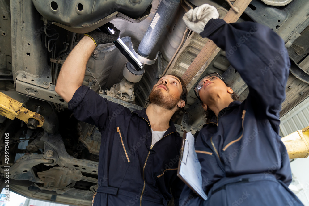 Male and female car mechanic worker working using wrench tool for ...