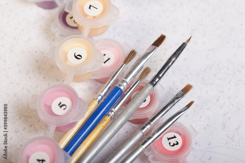 Brushes and paints for painting. On canvas with numbered sections ...