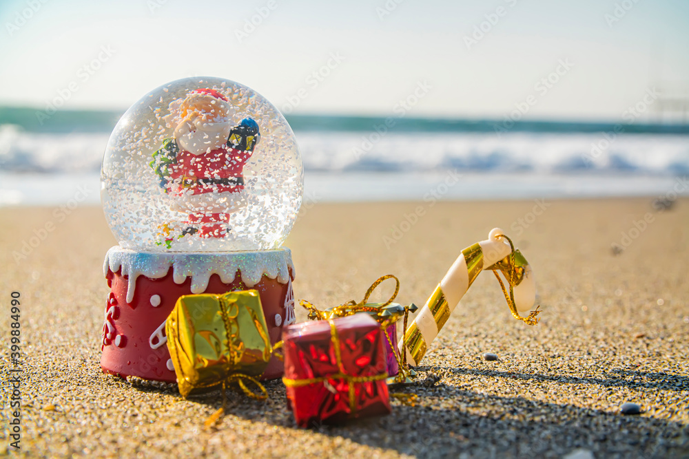 Christmas snow ball globe on the beach, by the sea as a symbol of ...