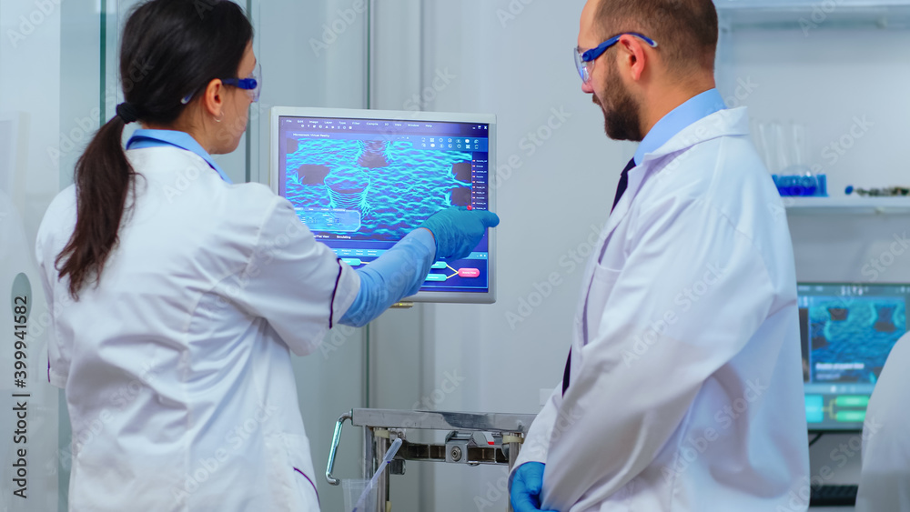 Scientist team arguing in front of computer looking at virus ...