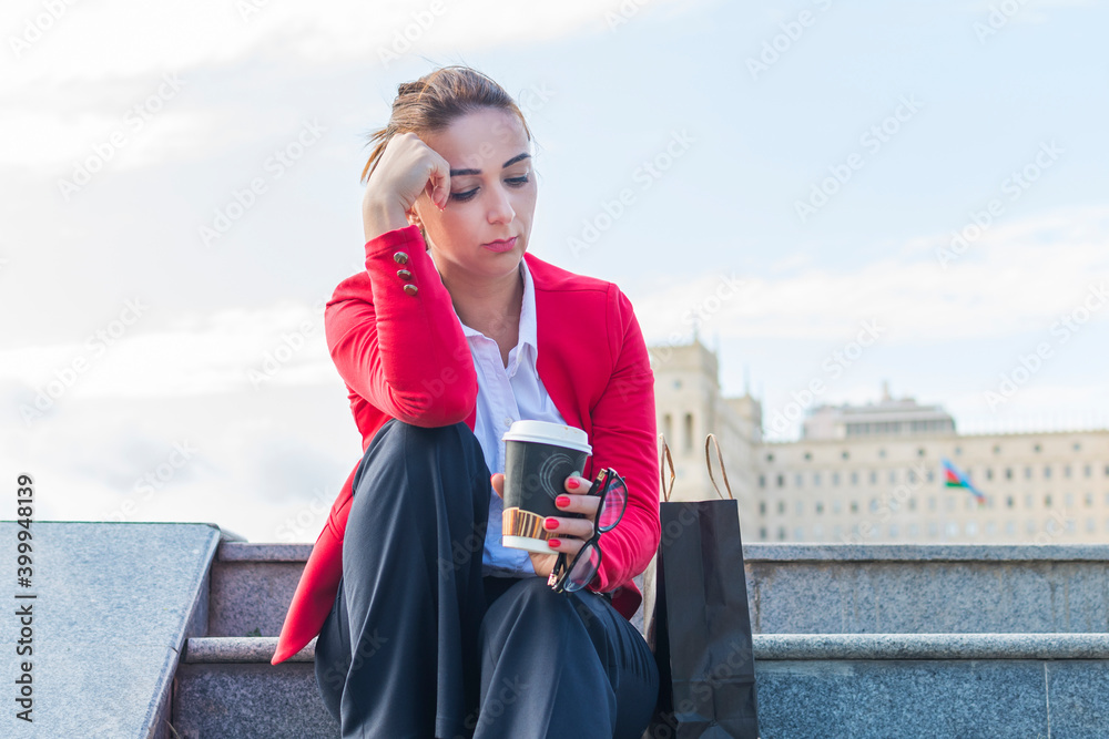 sad woman in a business suit sits on the steps. a business woman has ...