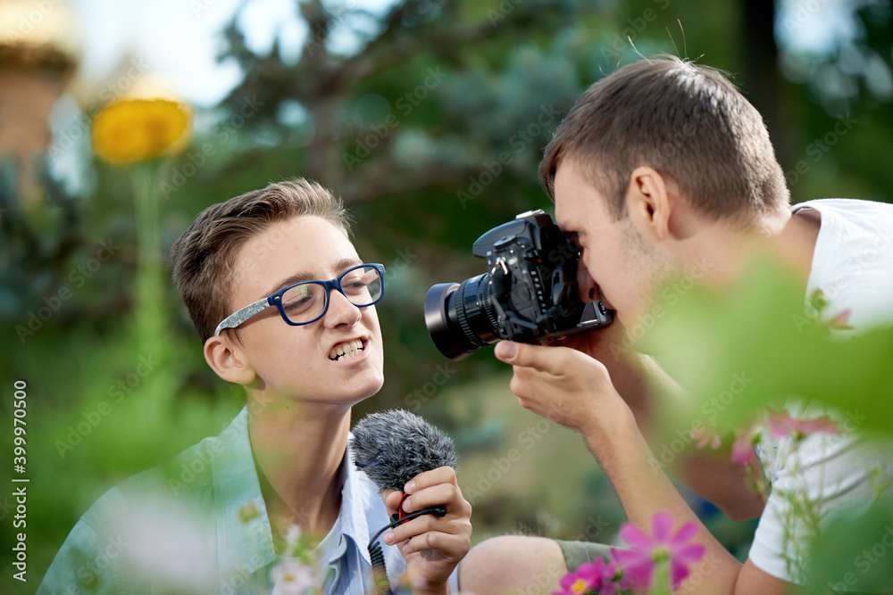 Cameraman shoots a video of an interview with a funny boy teenager ...
