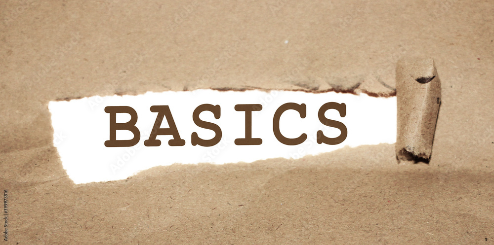 The word Basics appearing behind torn brown paper. Education concept ...