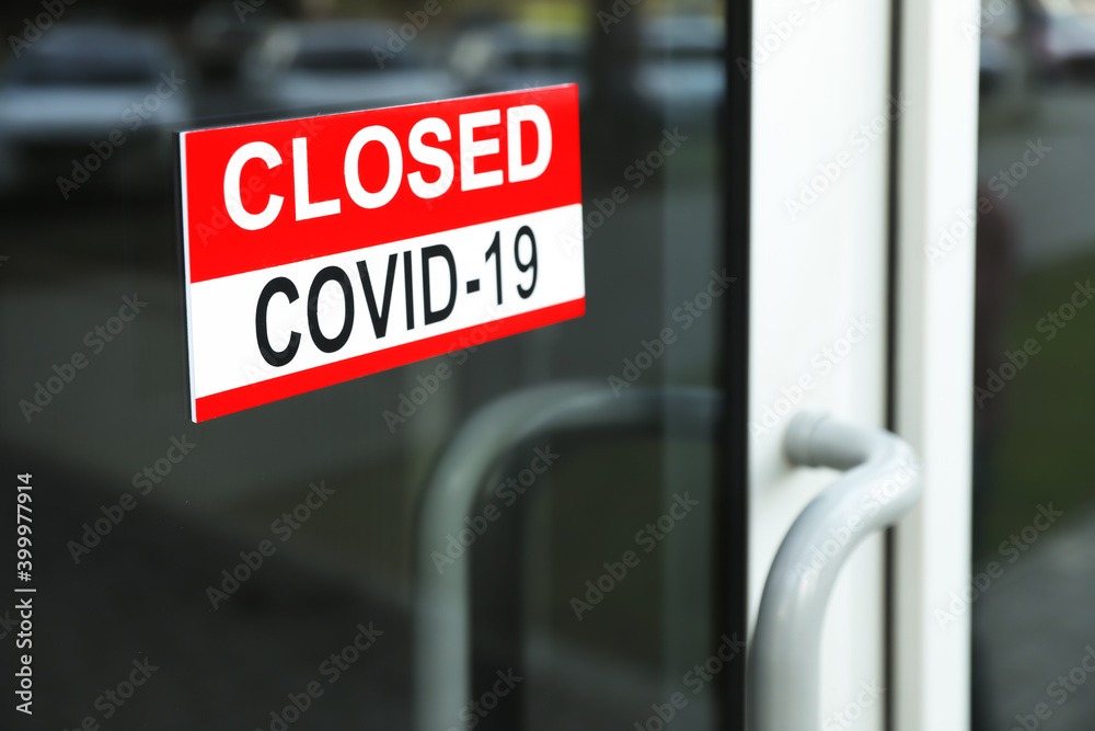 Red sign with words "Closed Covid-19" hanging on glass door Stock Photo ...