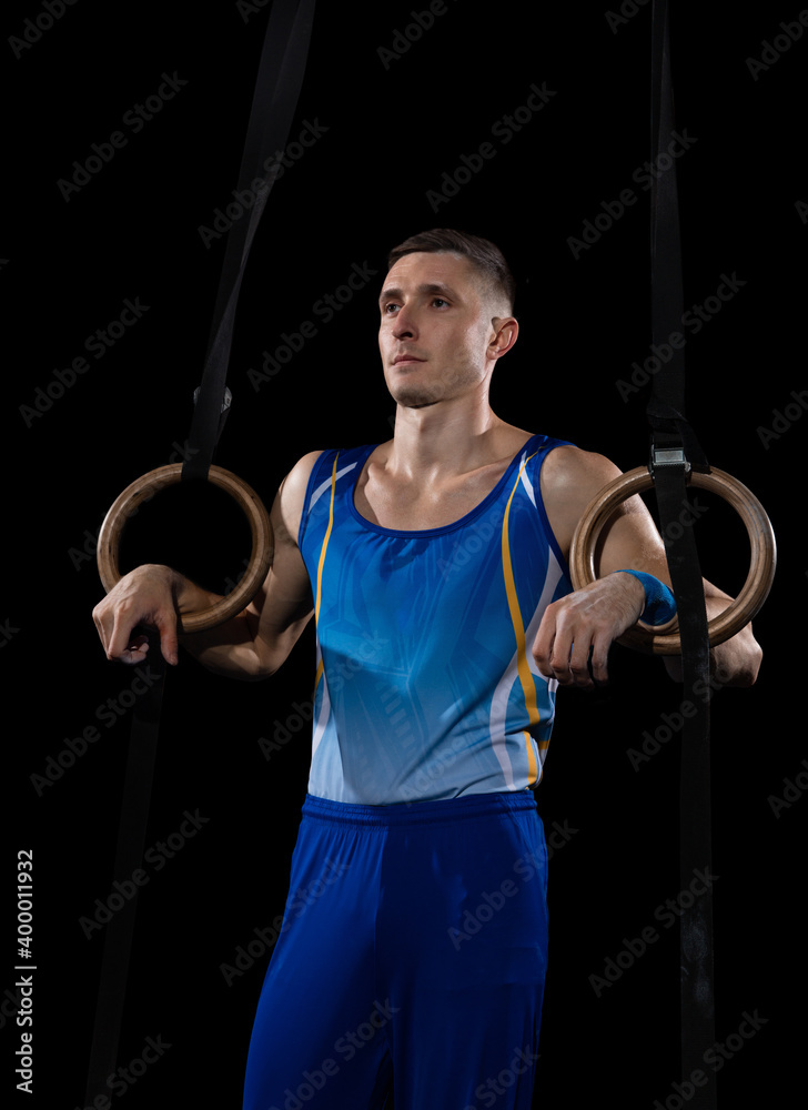 Strong. Muscular male gymnast training in gym, flexible and active ...