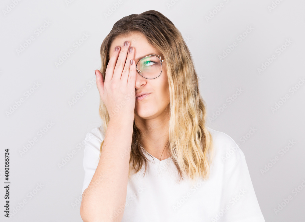 Tired sleepy woman holds face with her hand, has sad expression, cannot ...