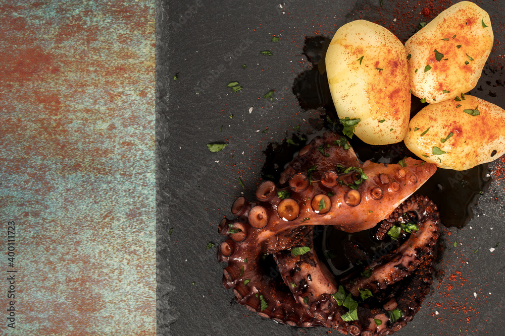Delicious grilled octopus tentacles with potatoes seasoned with Spanish ...