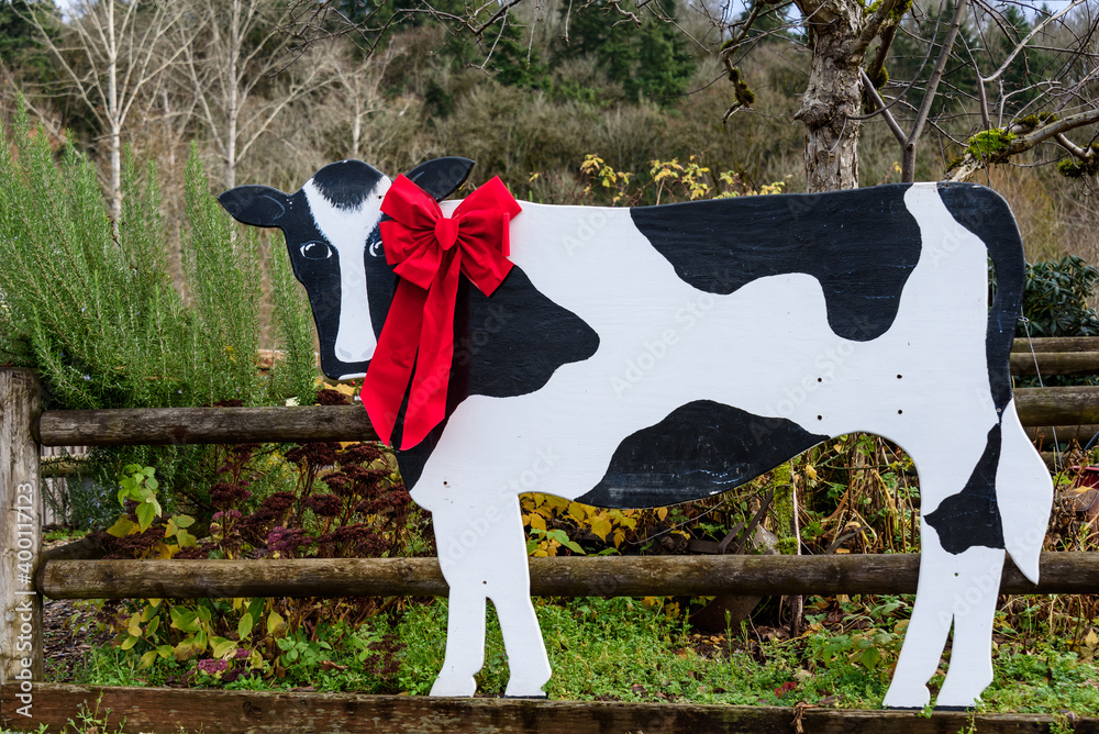 Wooden, black and white, life size cut out of a cow with a red bow ...