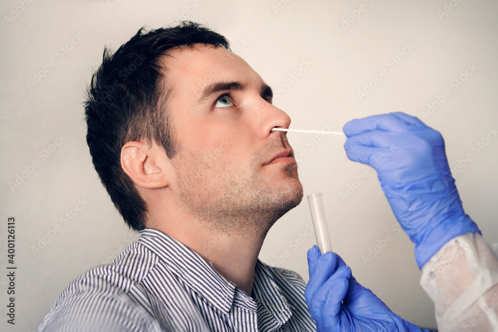 doctor taking nasal mucus test sample from male nose performing ...