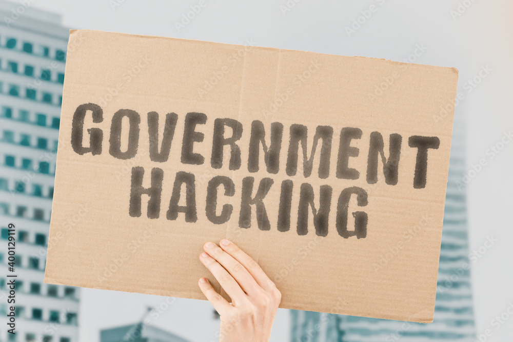 The phrase " Government hacking " on a banner in men's hand with ...