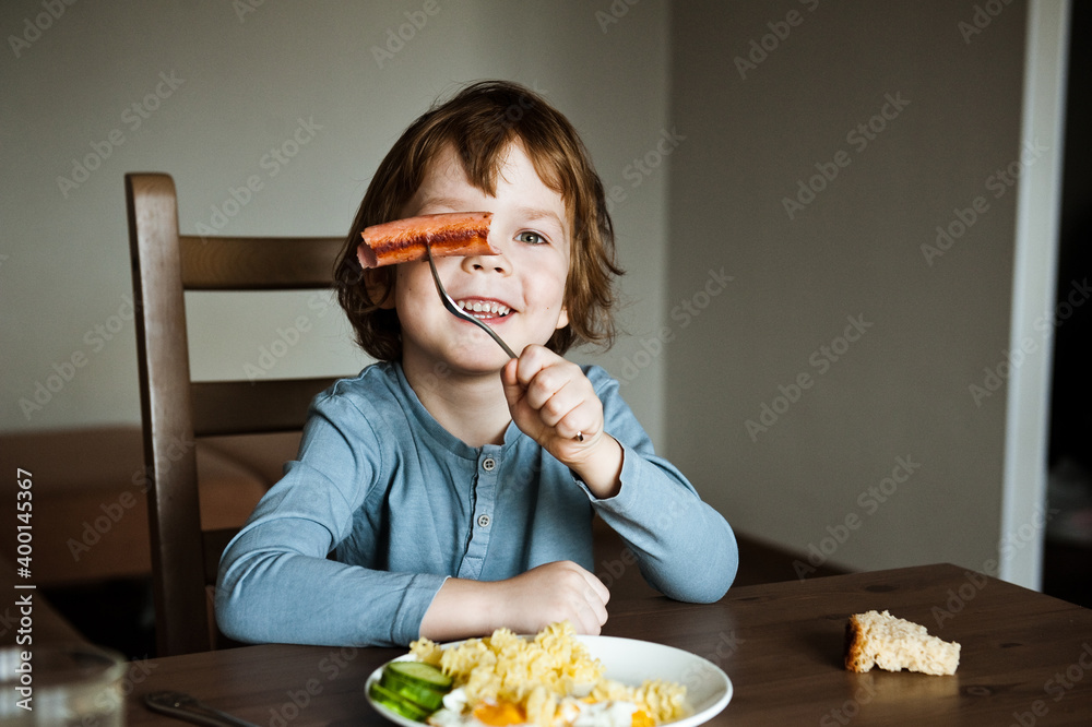 Cute boy eating dinner at home. Stock Photo | Adobe Stock