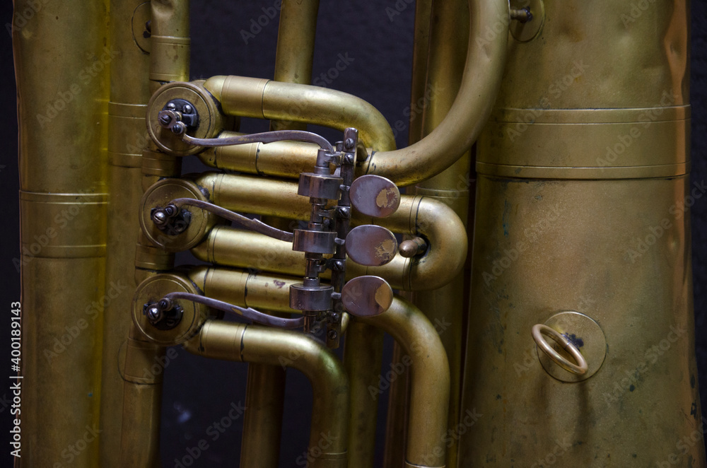 Musical wind instrument trumpet, tuba on the black background. Details ...