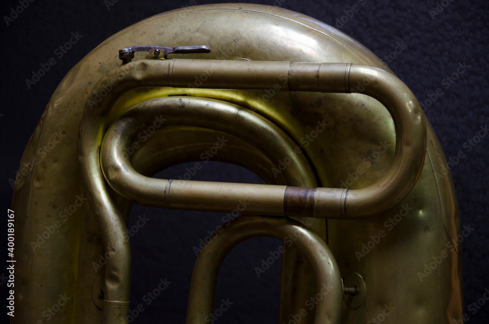 Musical wind instrument trumpet, tuba on the black background. Details ...