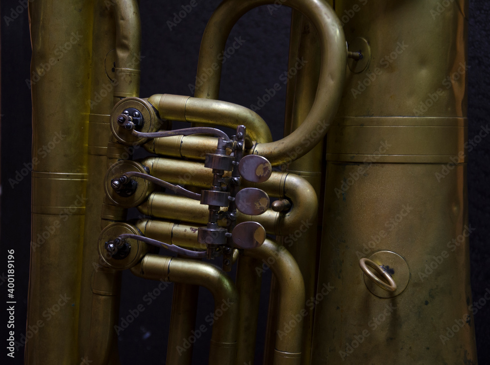Musical wind instrument trumpet, tuba on the black background. Details ...