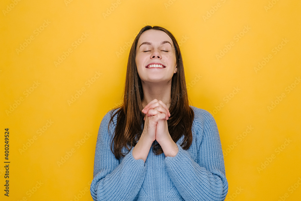 Hopeful young woman clenching fists making wish praying asking dreams ...