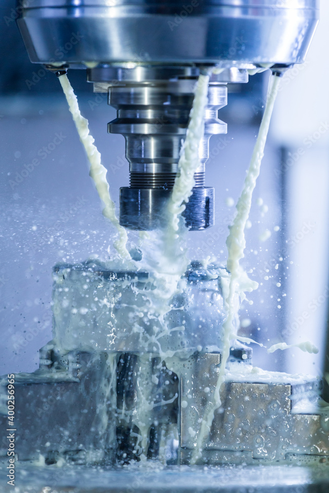 Vertical photo of industrial wet milling process in 5-axis cnc machine ...