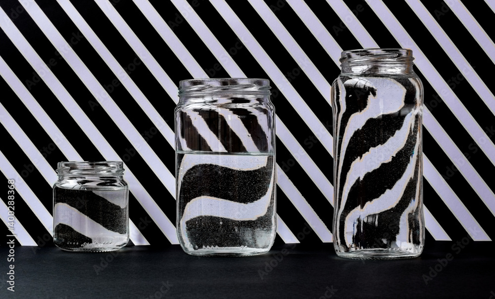 Three Jars with water on a black and white background of diagonals ...