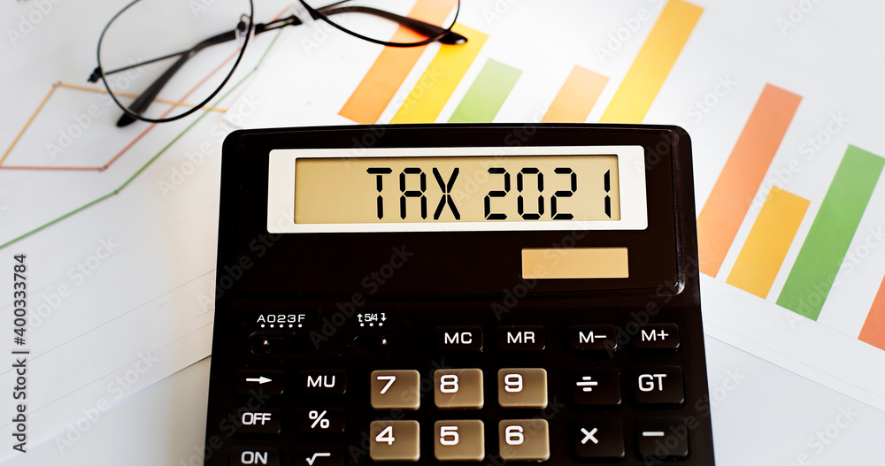 calculator with the word TAX 2021 on the display with chart and glasses ...