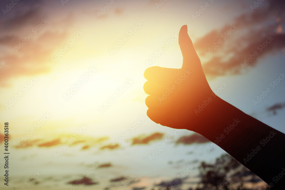 Silhouette like hand symbol thumbs up on meadow in sunset Stock Photo ...