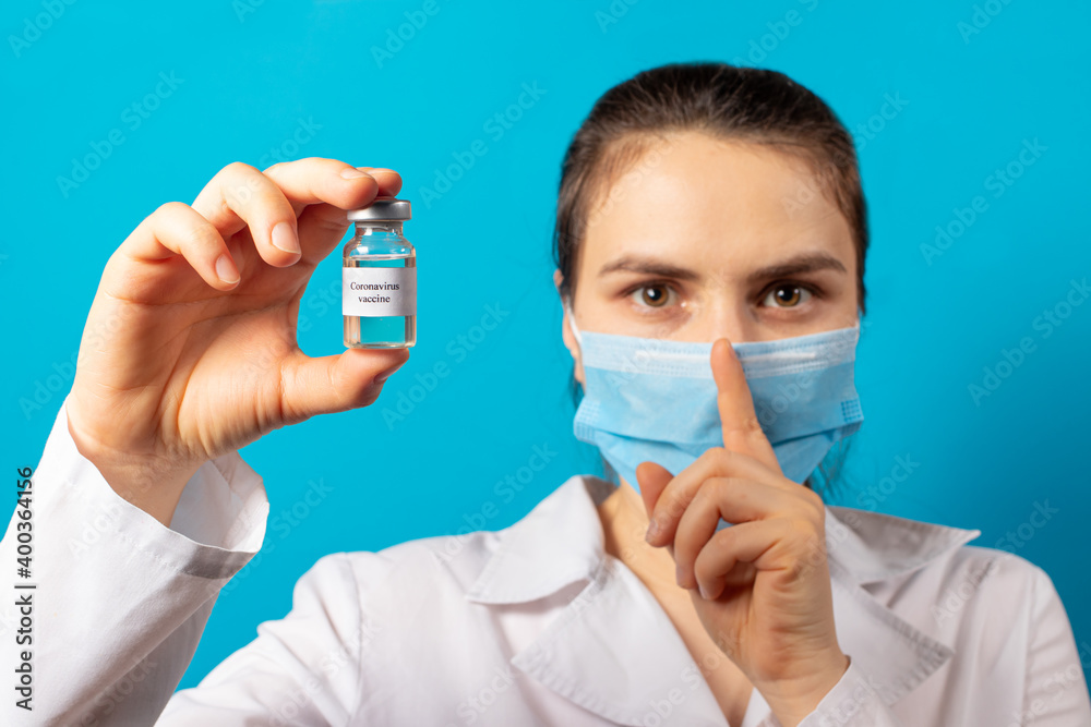 A doctor or laboratory technician holds a test tube with a vaccine ...