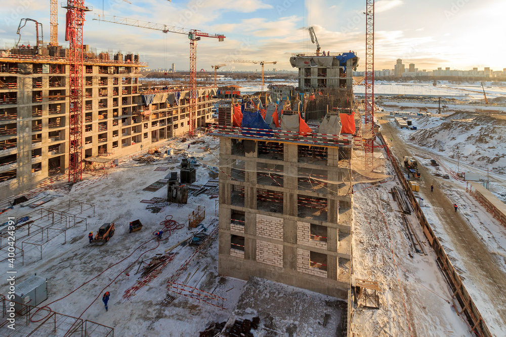 Pouring concrete. Construction site. Sunny snowy winter day. Bar bender ...