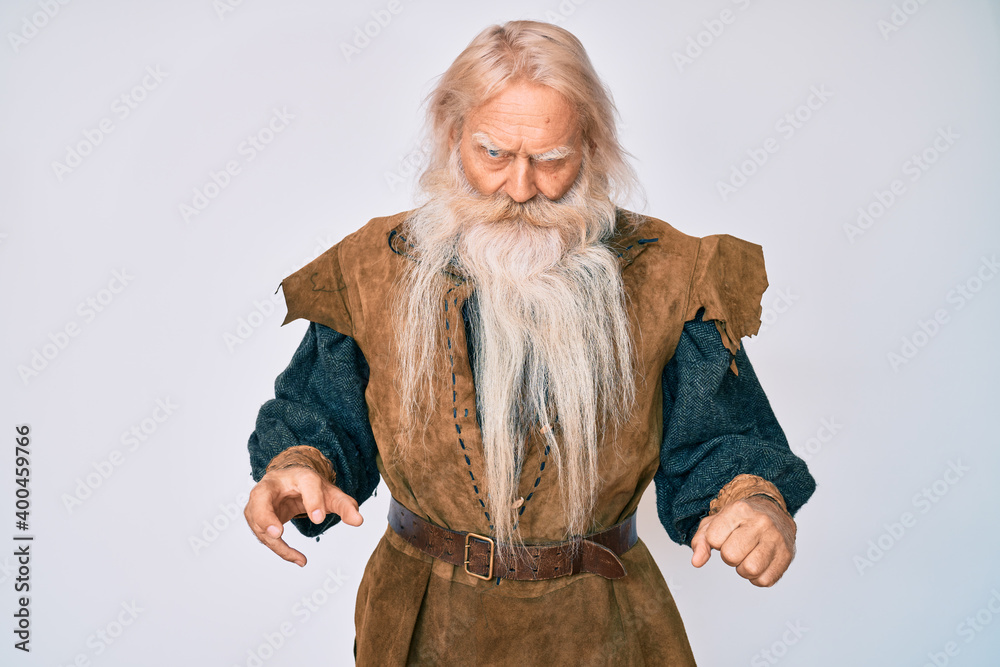 Old senior man with grey hair and long beard wearing viking traditional ...
