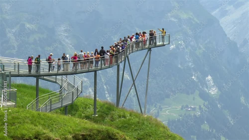 Grindelwald First. Tourists enjoy Swiss Alps panoramic views from the ...