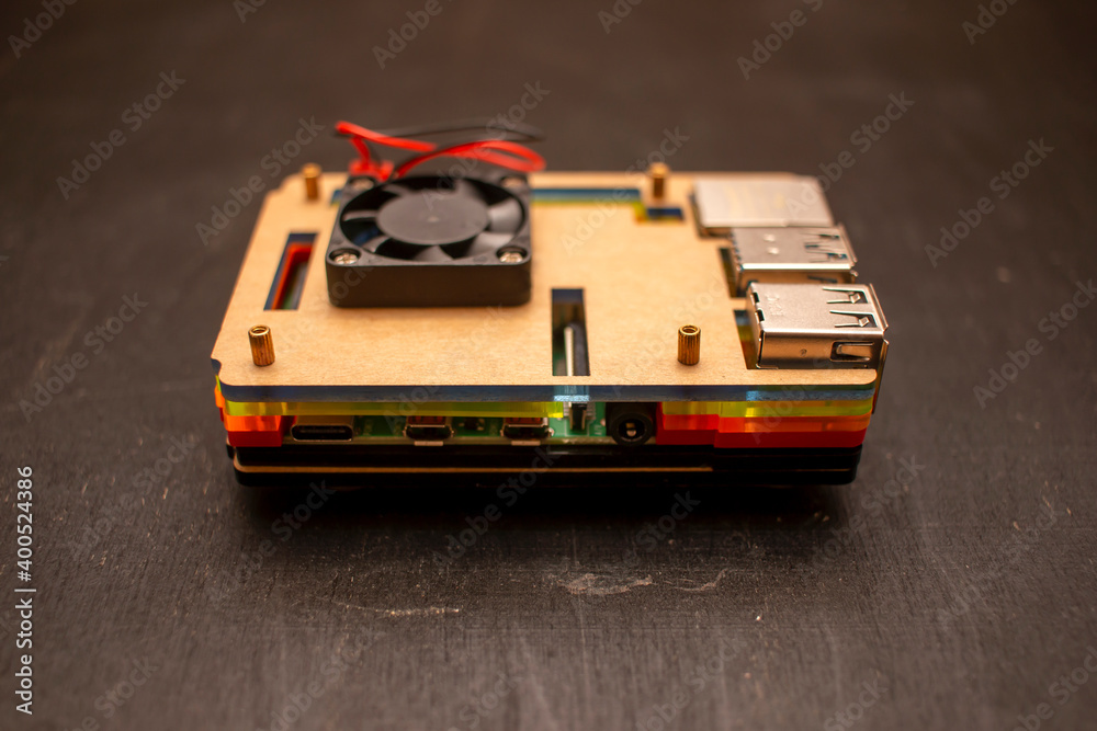A single-board microboard computer in multi-colored case with a fan ...