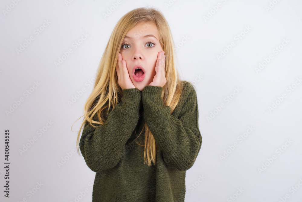 Scared terrified Caucasian kid girl wearing green knitted sweater ...