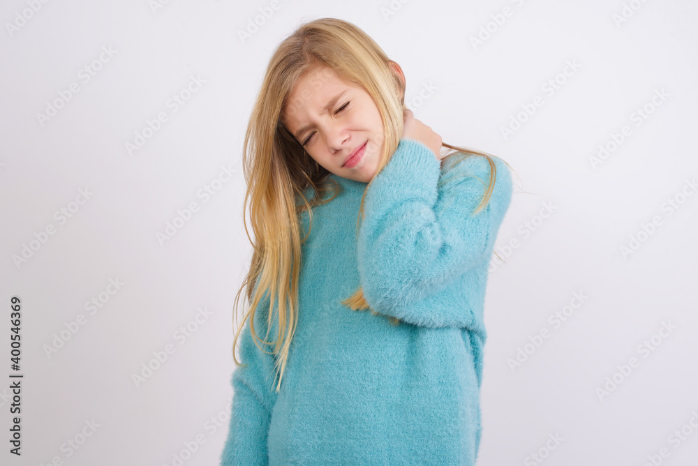 Cute Caucasian kid girl wearing blue knitted sweater against white wall ...