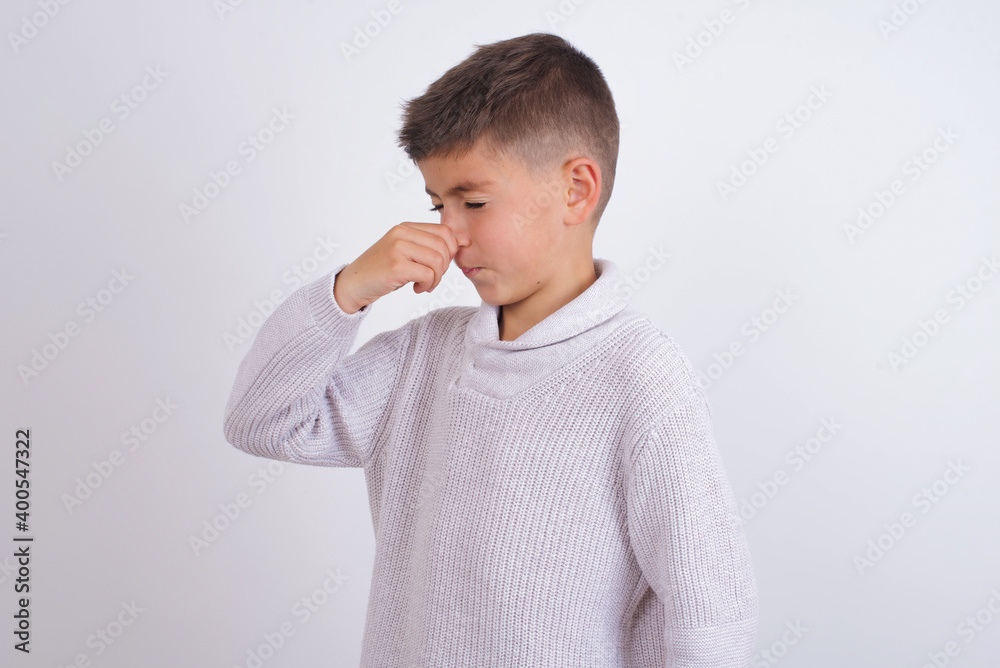 Cute Caucasian kid boy wearing knitted sweater against white wall ...