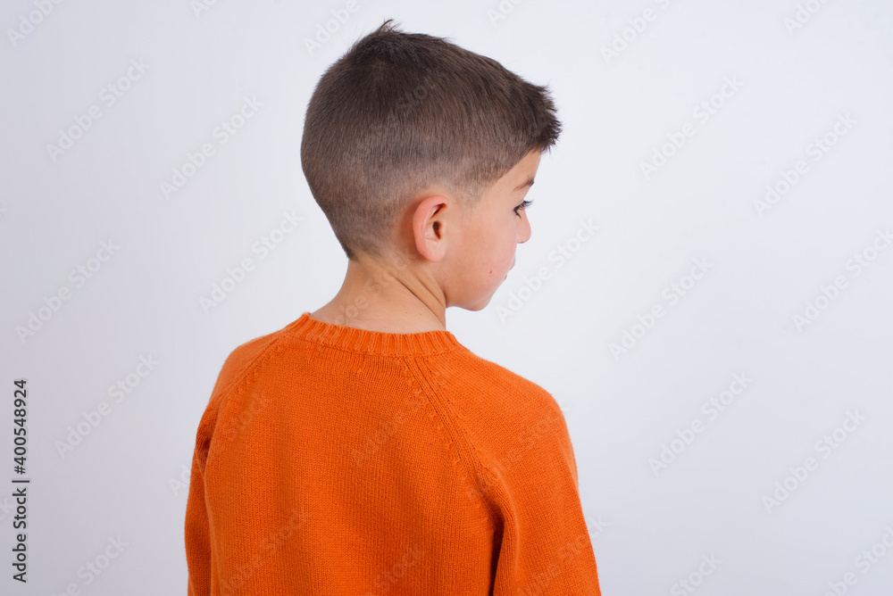 The back side view of a Cute Caucasian kid boy wearing knitted sweater ...