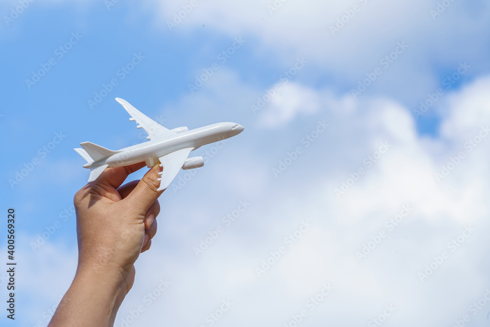 Man hands hold a plane model on the blue sky with white clouds for ...