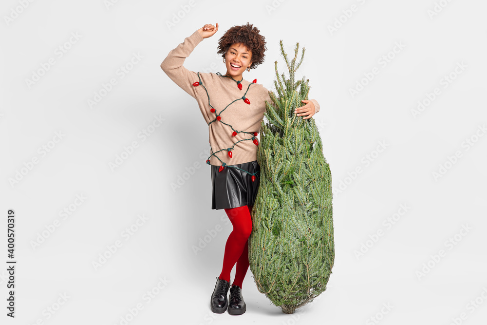 Happy carefree Afro American woman raises arm poses in full length with ...