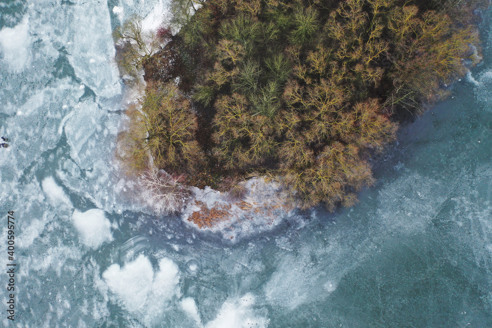 top view of an island in the middle of a frozen lake and fishermen ...