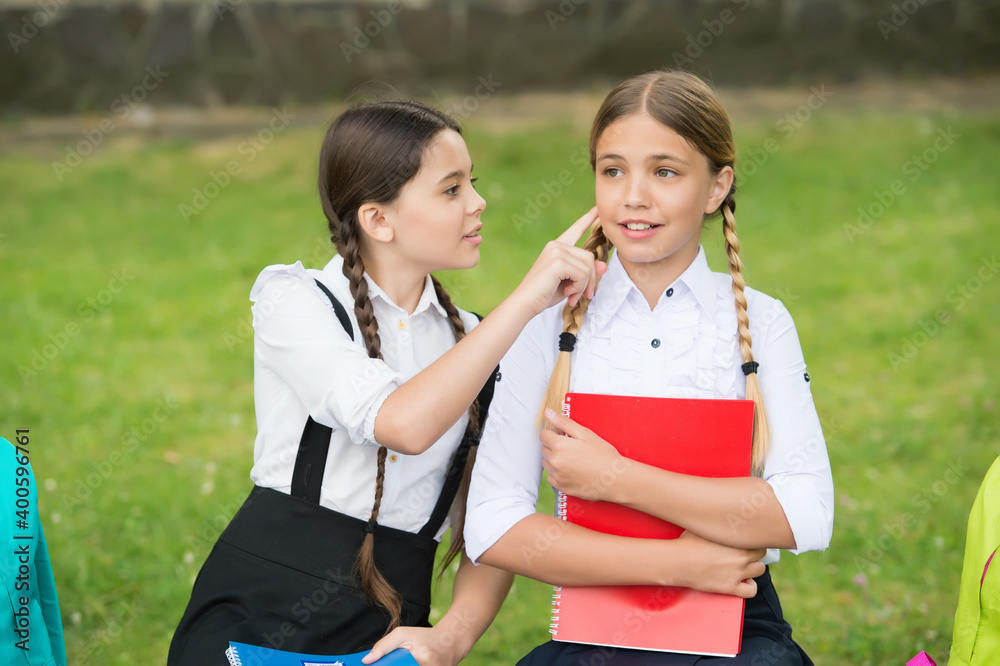 Little child in school uniform touch skin of girl classmate sitting on ...