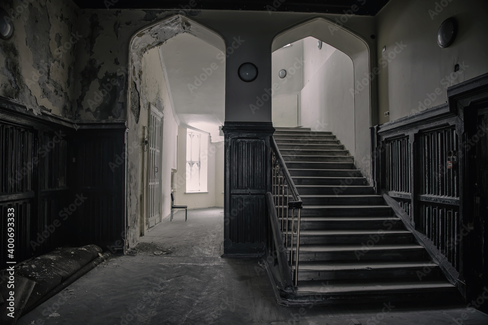 A beautiful hall with a staircase in an old abandoned house. An old ...
