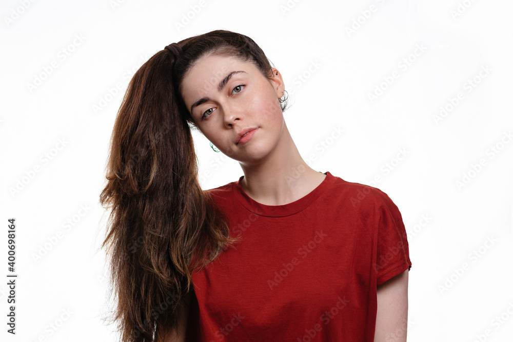 Portrait of a young caucasian woman with a ponytail hanging over her ...