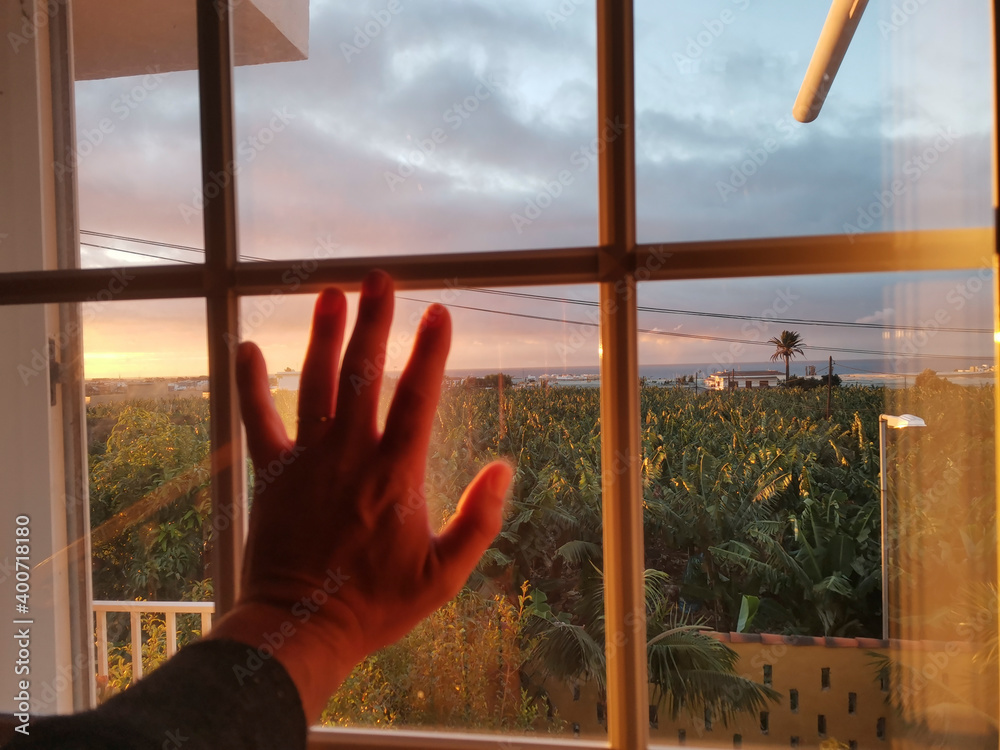 Hand of man touch the transparent glass of the window at home looking ...