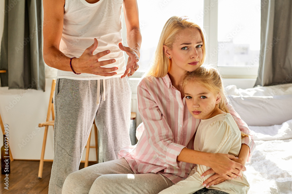 angry father scolds daughter and wife, family problems. scared child ...