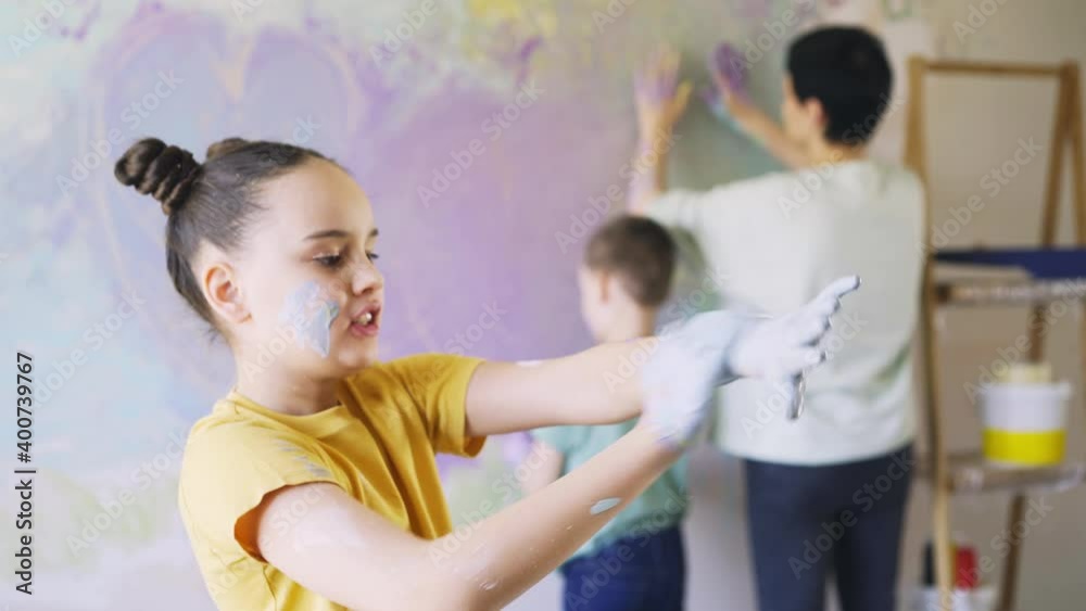 Portrait girl smeared different color paint fool around, gesturing ...