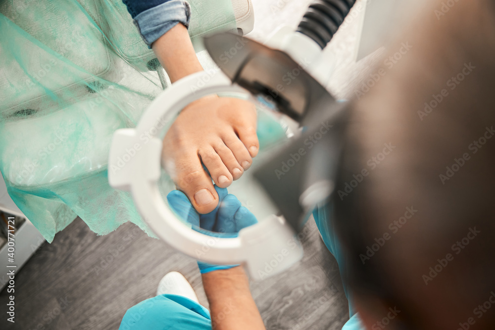 Attentive medical worker looking through magnifying glass Stock Photo ...